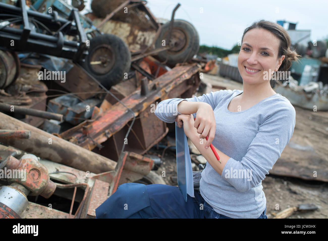 woman working next to a rusted metal scrap pile Stock Photo - Alamy