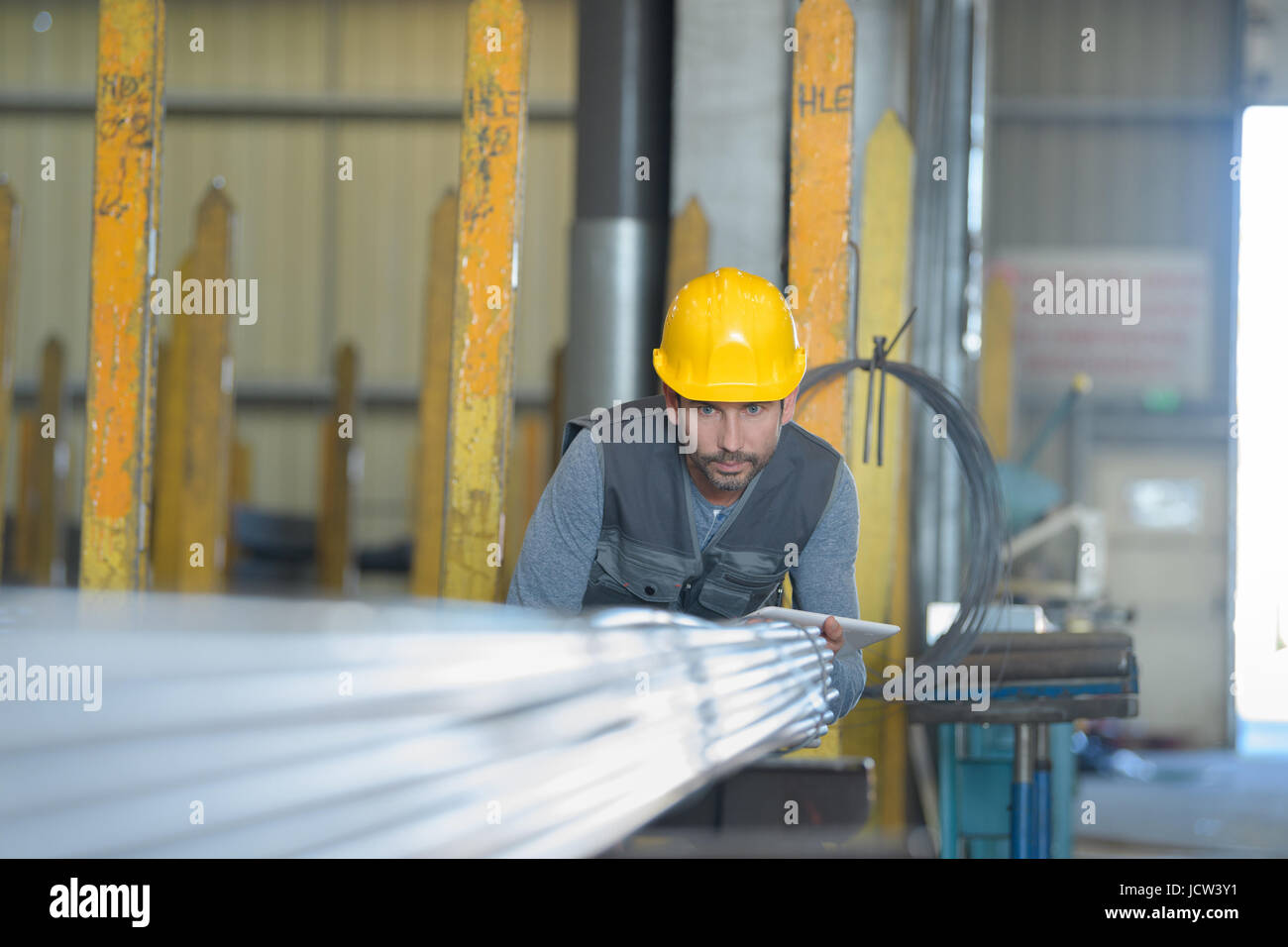 worker moving steel bar storing inside warehouse Stock Photo - Alamy