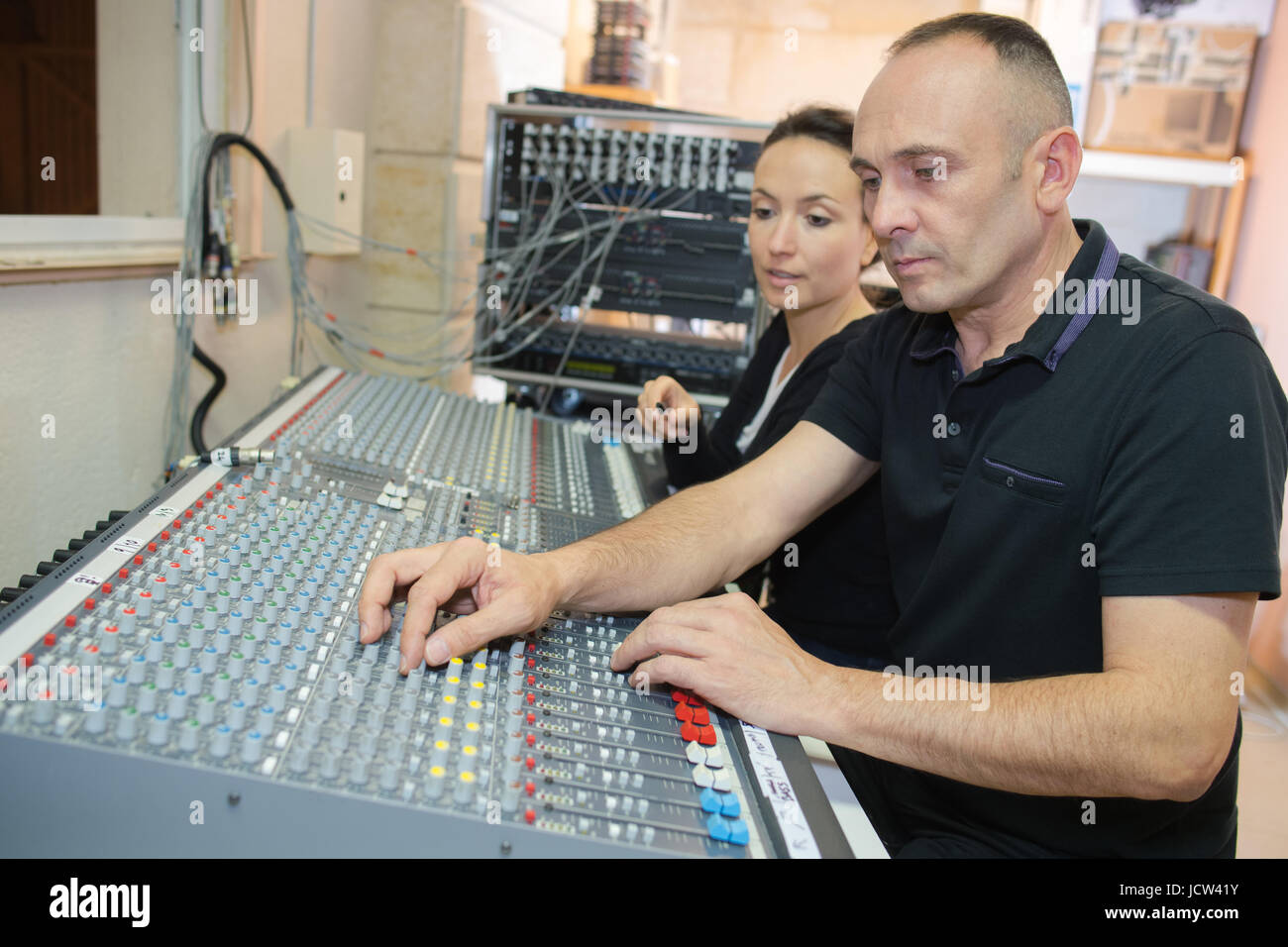 sound engineers on mixing controller Stock Photo - Alamy