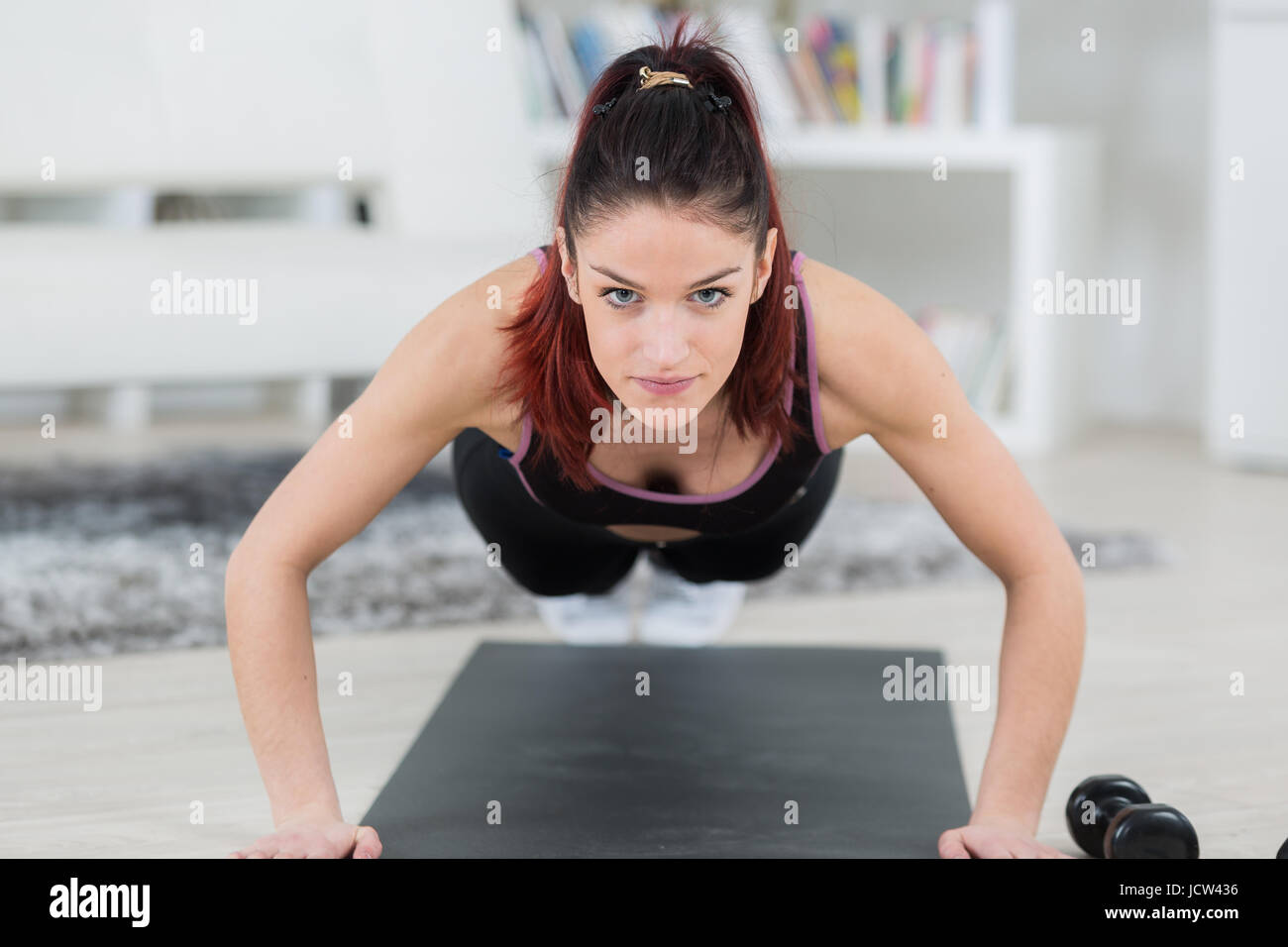 strong young caucasian woman doing push ups indoors Stock Photo - Alamy