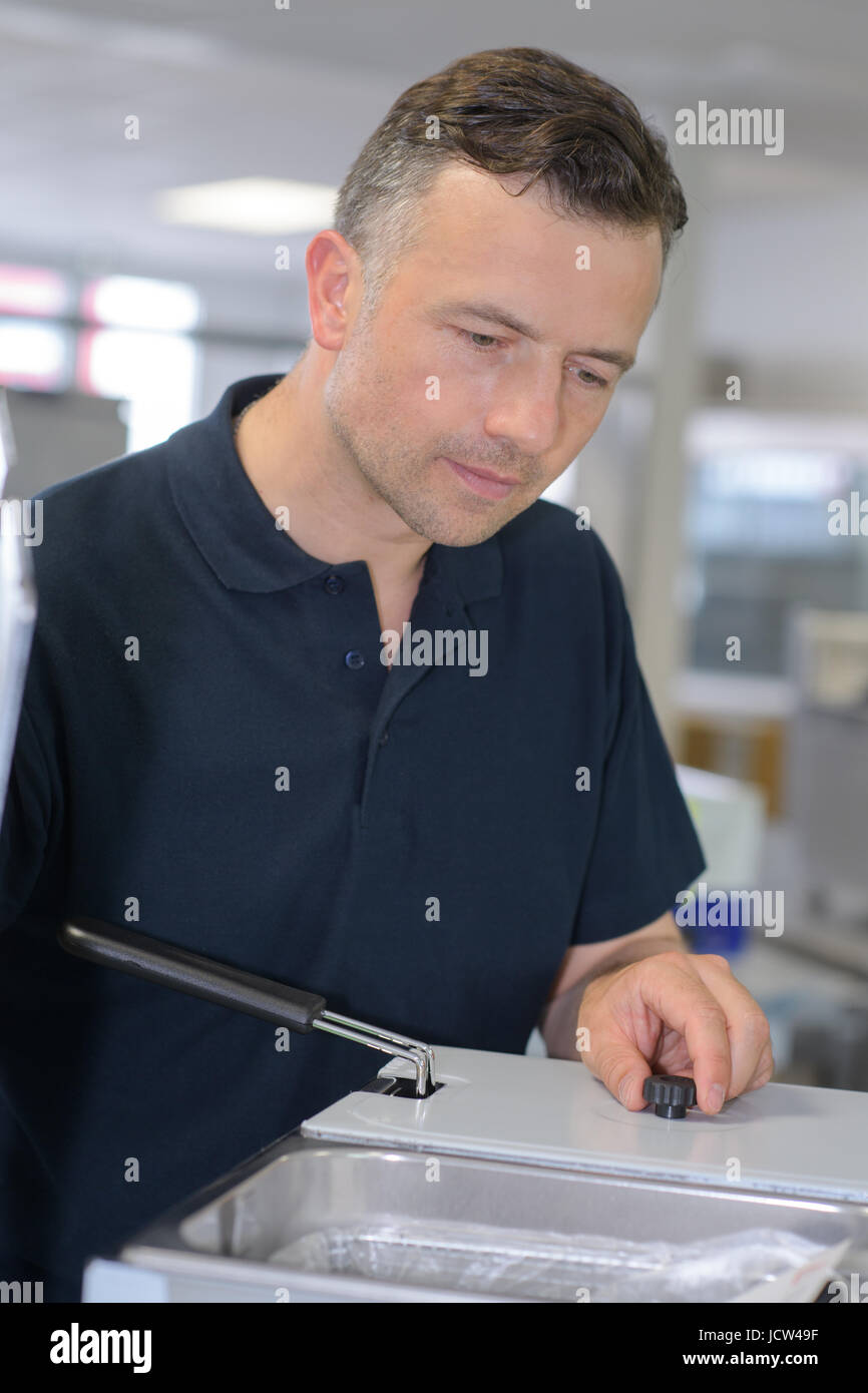 man fixing a deep-fryer Stock Photo - Alamy