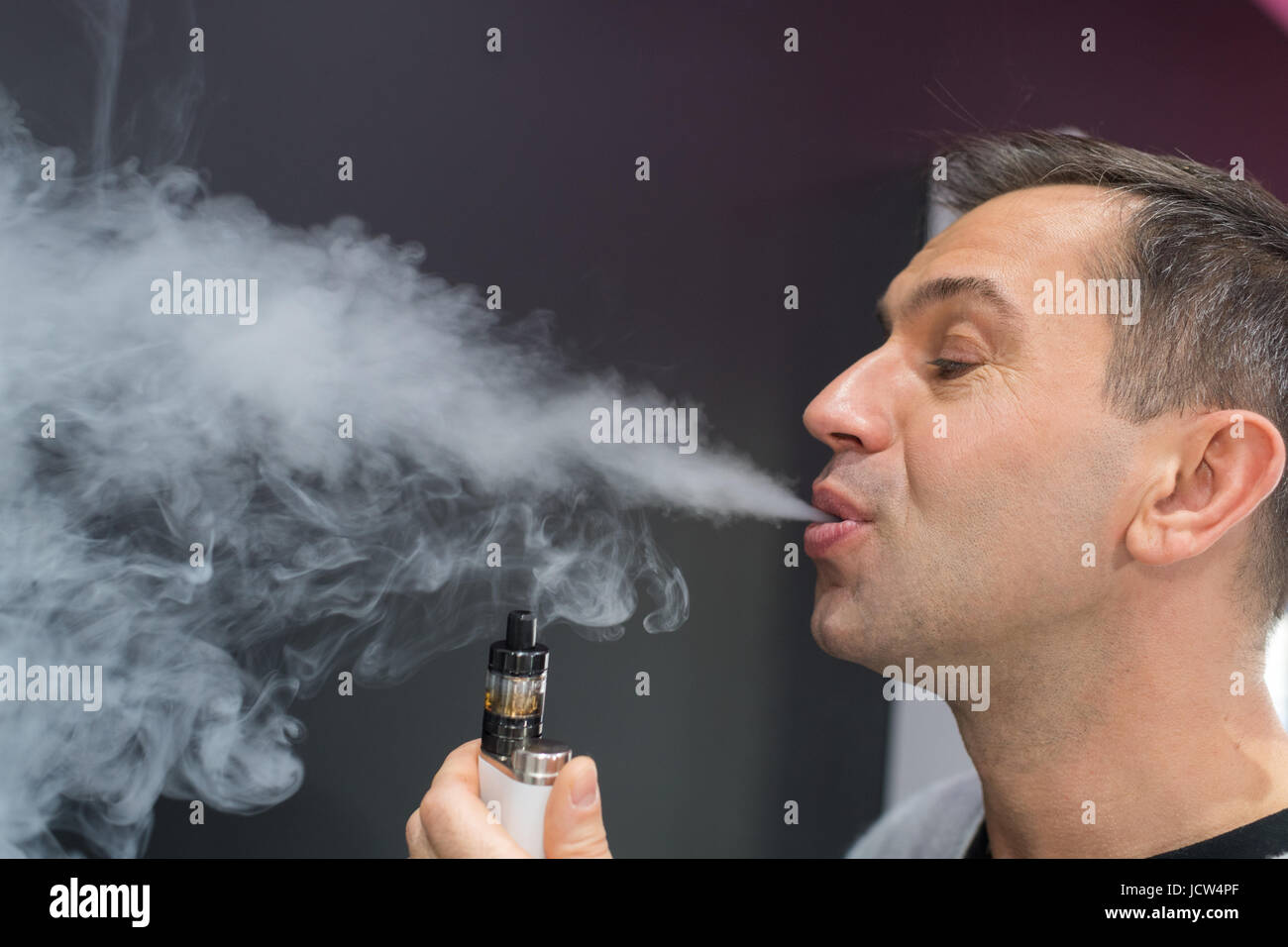man exhaling vapor from an electronic cigarette Stock Photo - Alamy