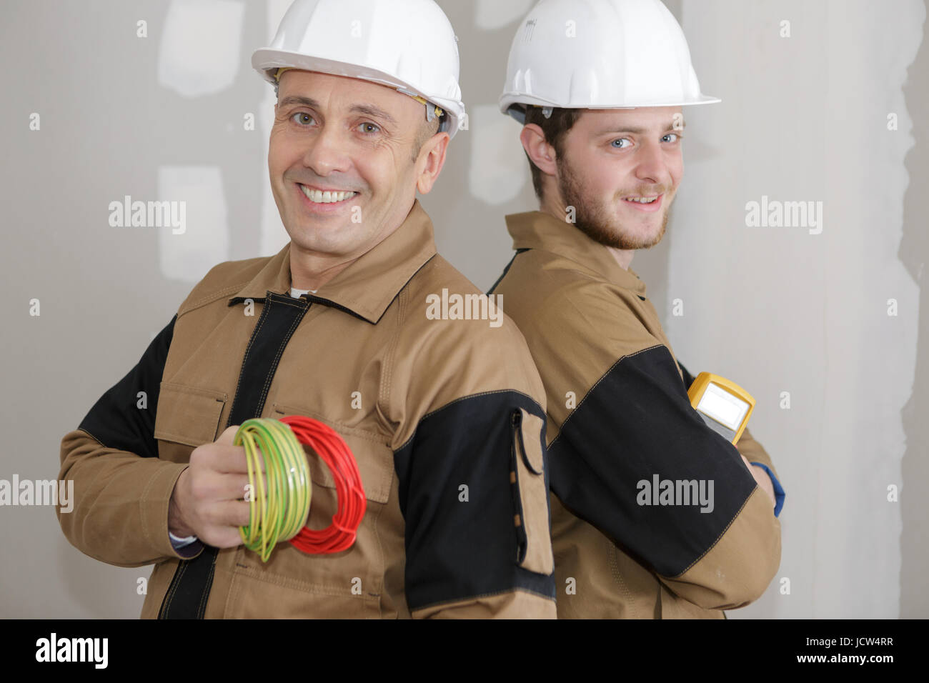 smiling builders with a safety helmet Stock Photo - Alamy