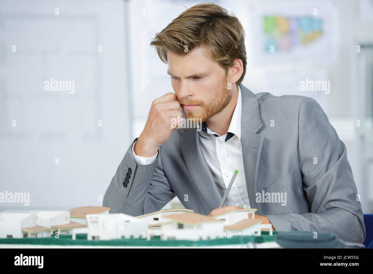 male architect looking at house models Stock Photo - Alamy