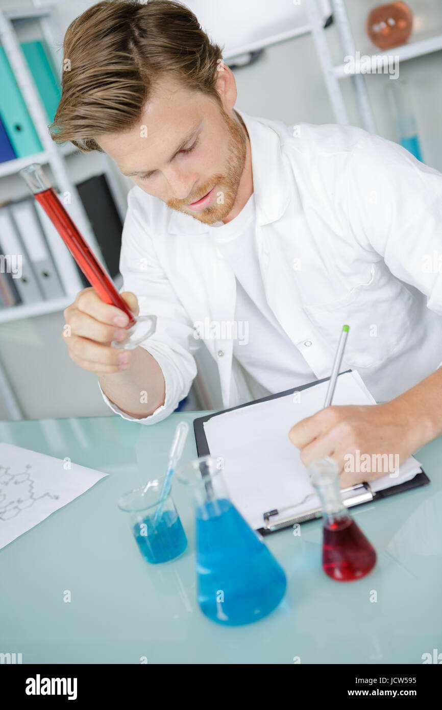 research worker doing experiments with chemical liquid at laboratory ...