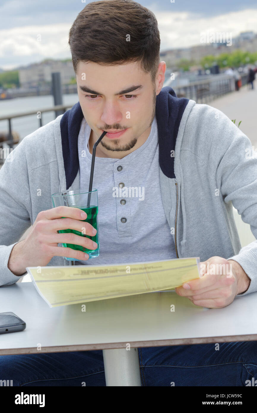 man drinking and reading book in cafeteria Stock Photo - Alamy