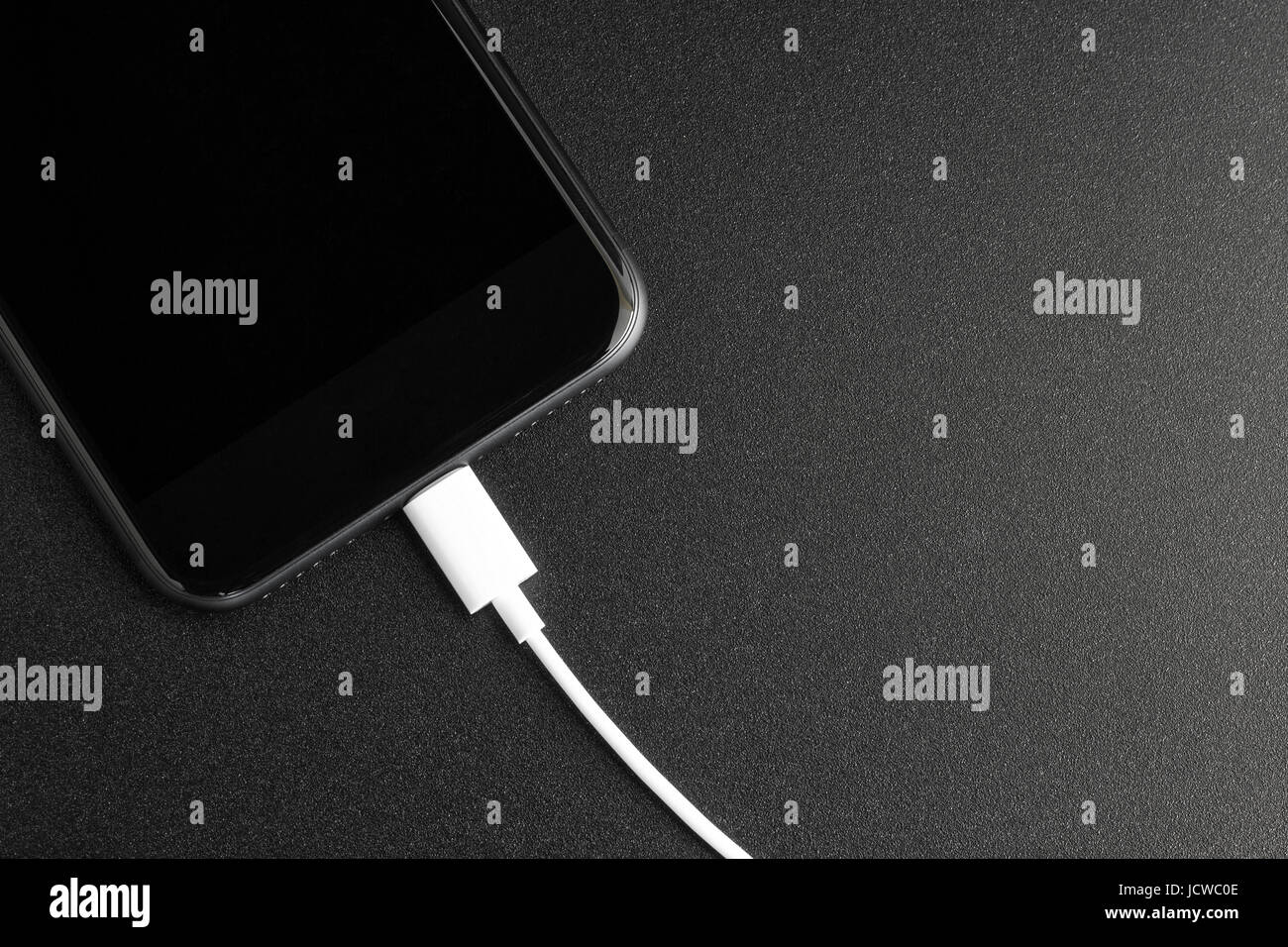 phone connecting usb port on black background top view Stock Photo - Alamy