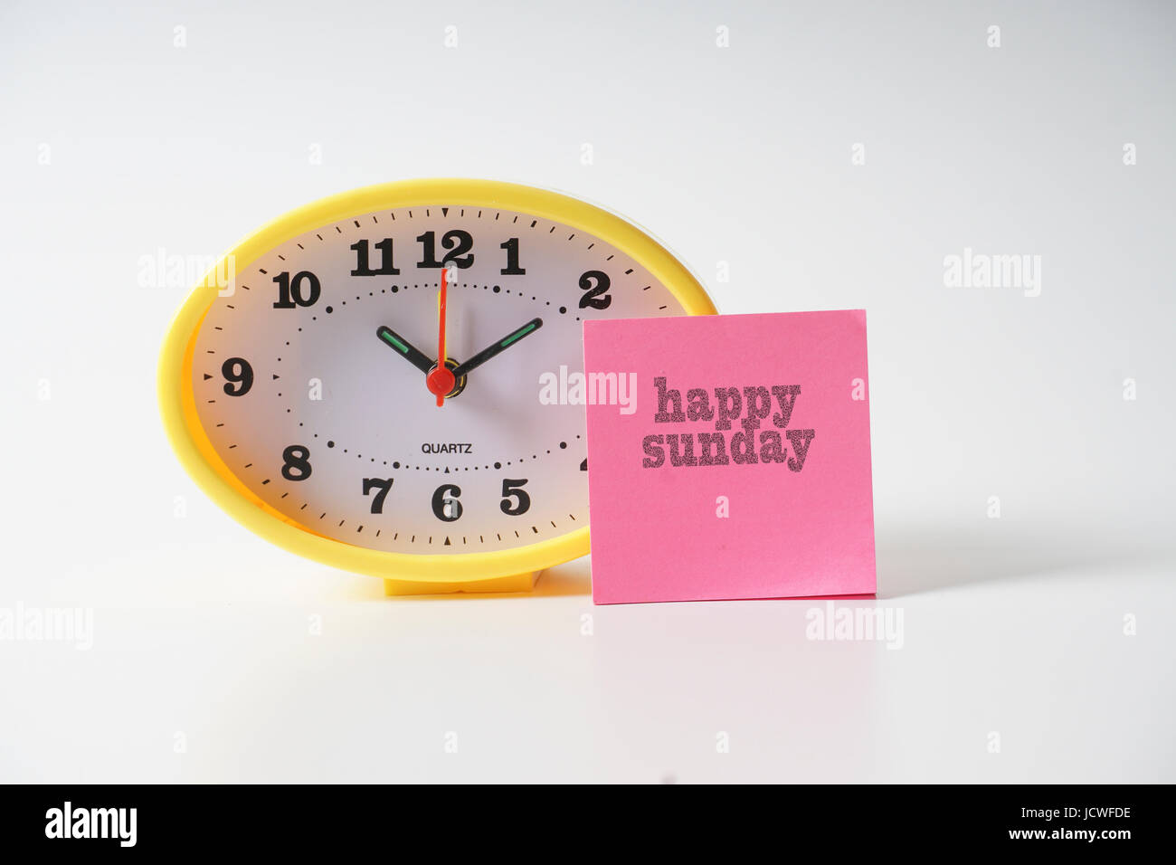Yellow table clock with time management conceptual text on the note ...