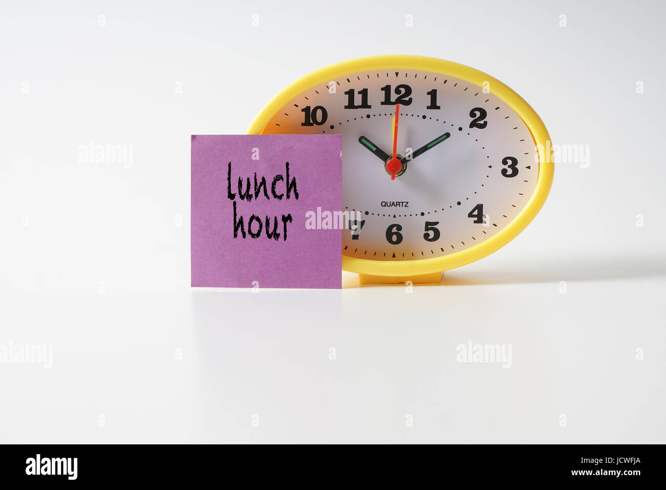 Yellow table clock with time management conceptual text on the note ...