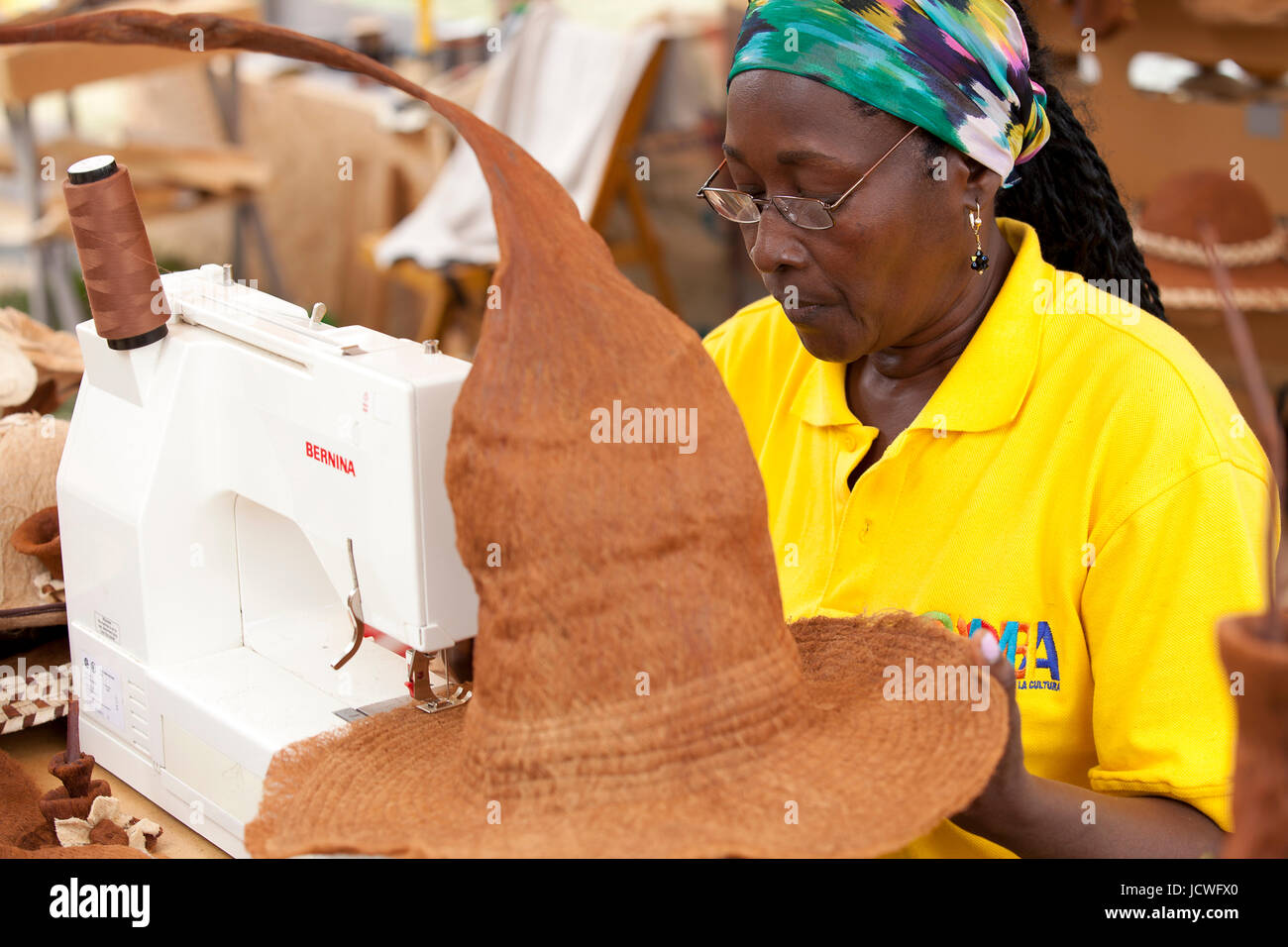 Afro-Colombian woman hat maker working with a sewing machine using ...
