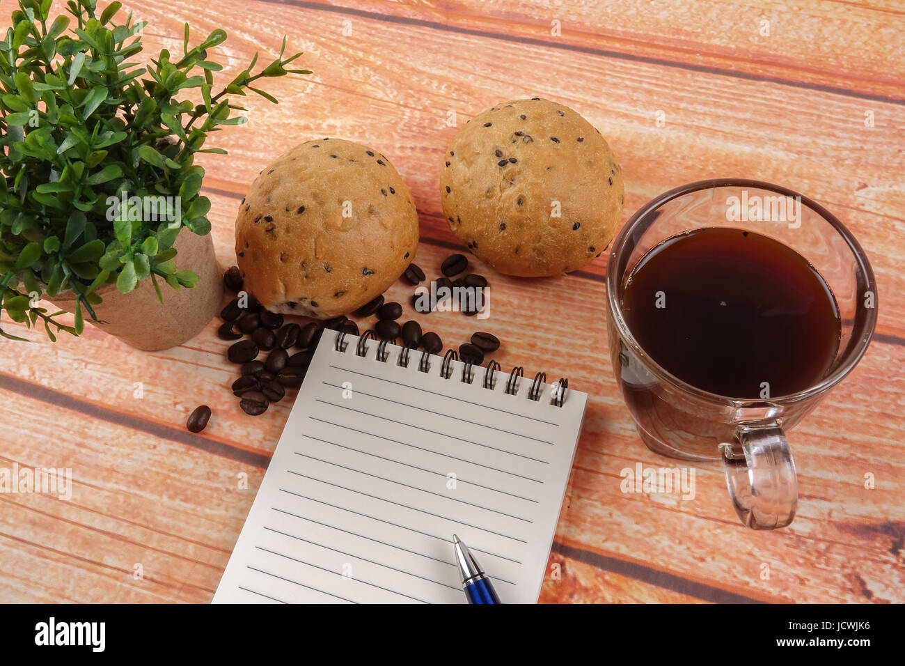 Morning breakfast concept with coffee,bun, post it notes on wooden ...
