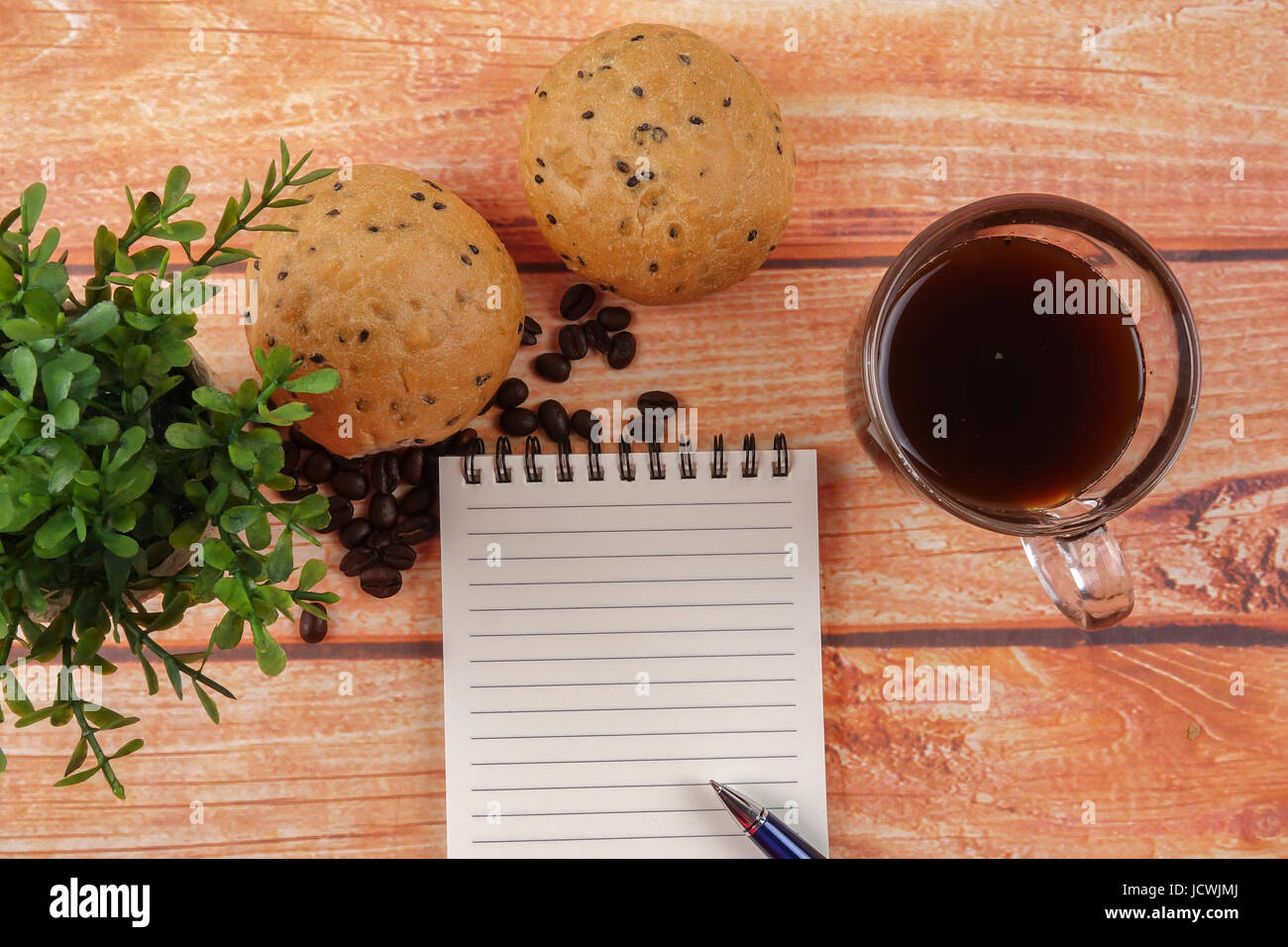 Morning breakfast concept with coffee,bun, post it notes on wooden ...