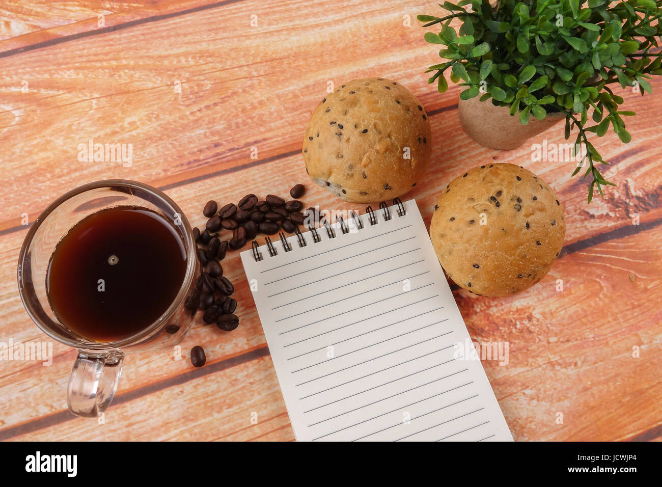 Morning breakfast concept with coffee,bun, post it notes on wooden ...