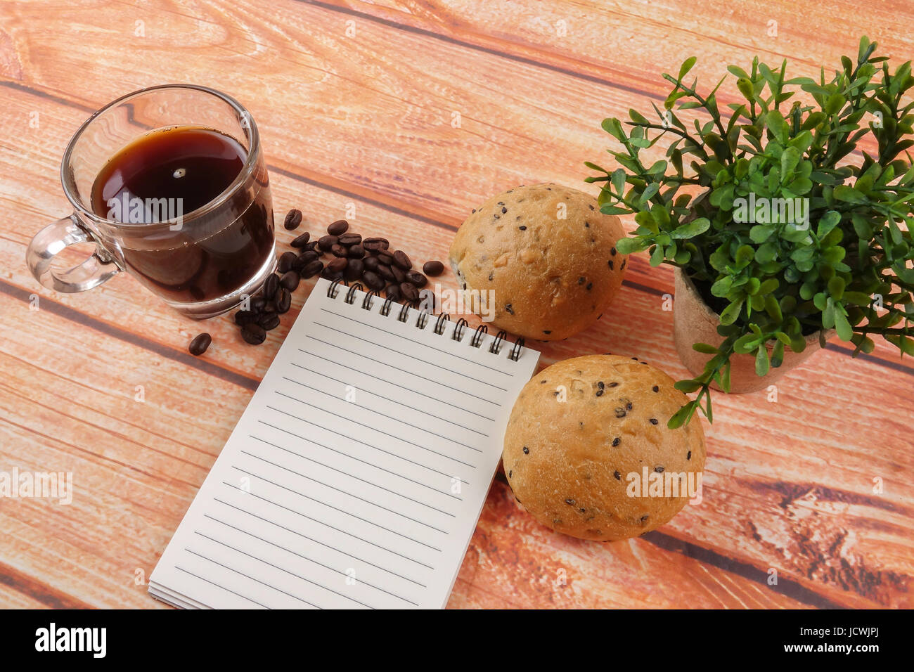 Morning breakfast concept with coffee,bun, post it notes on wooden ...