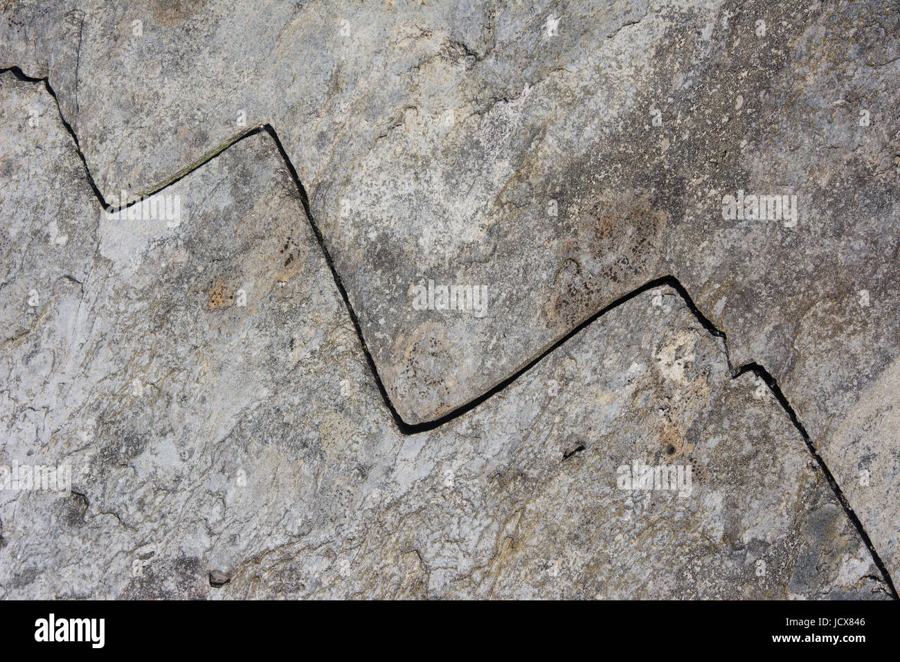 Rock texture with lichen and zig zag crack for backgrounds and textures. Zig zag crack resembles ...