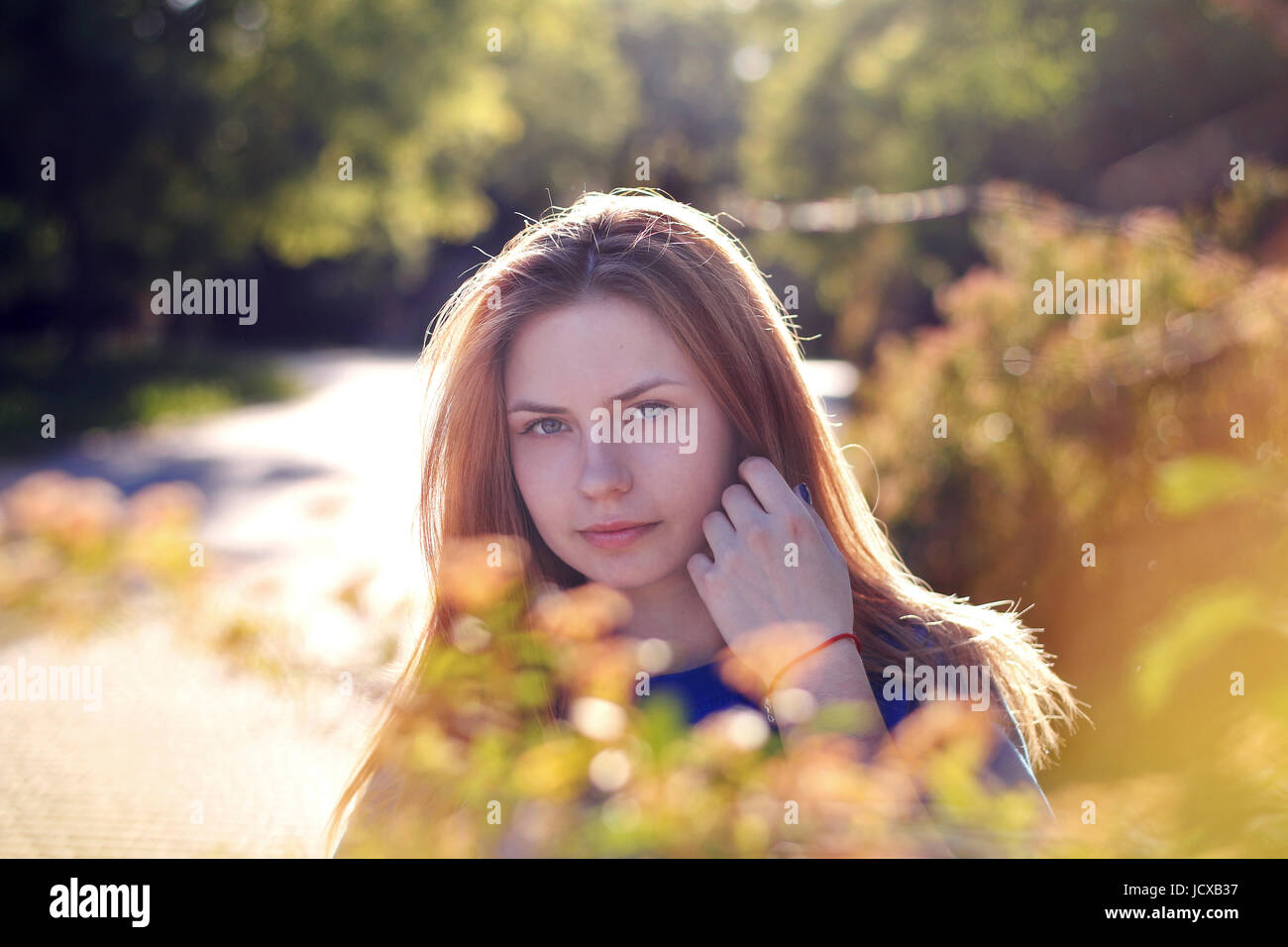 warm portrait of a young pretty girl in the park Stock Photo - Alamy