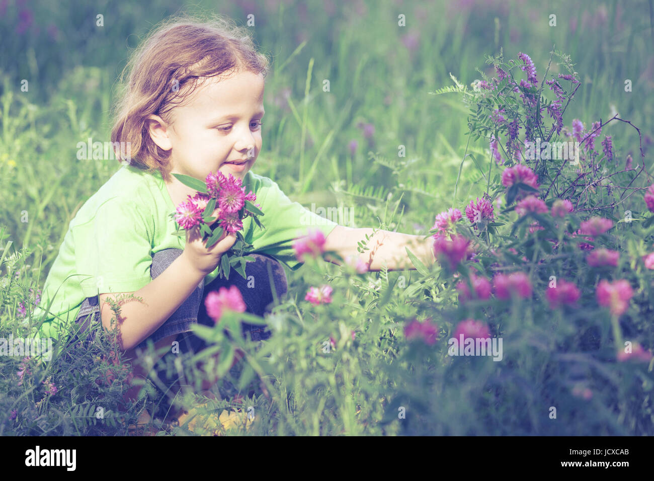 Cute little boy playing with flowers in park at the day time Stock ...