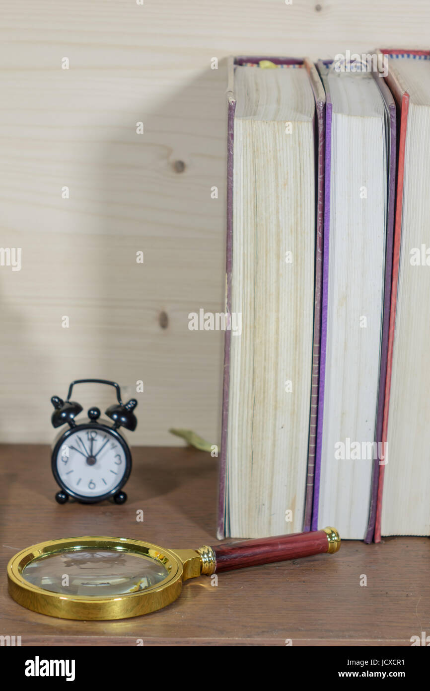 book magnifying glass and clock on the wood floor Stock Photo - Alamy