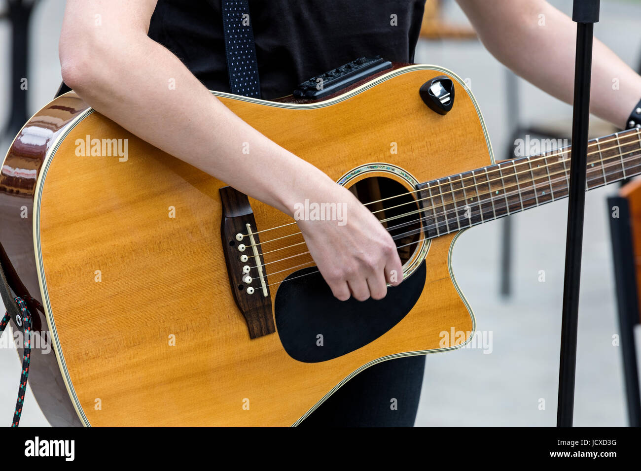 young woman playing acoustic guitar outdoors closeup Stock Photo - Alamy