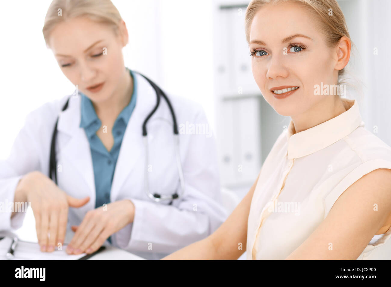 Doctor and patient sitting at the desk Stock Photo - Alamy