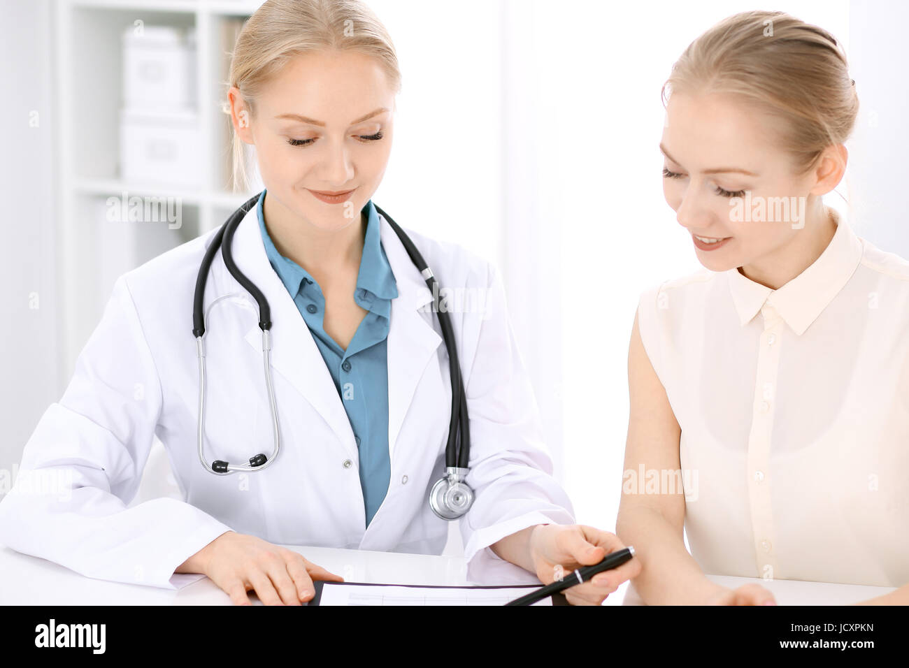 Doctor and patient sitting at the desk Stock Photo - Alamy