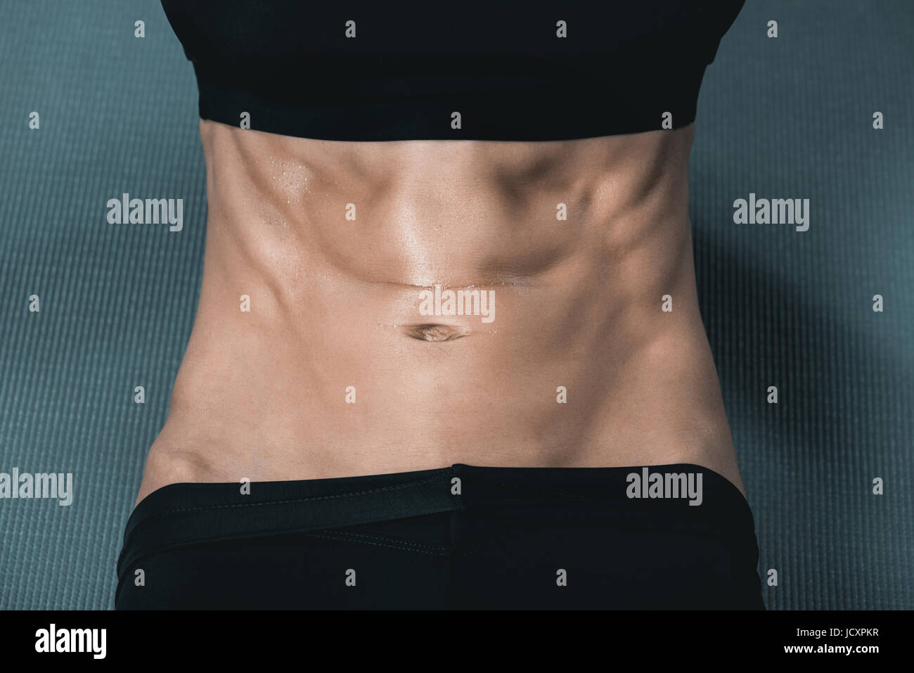 woman's muscular body with abs on mat. sport concept Stock Photo - Alamy