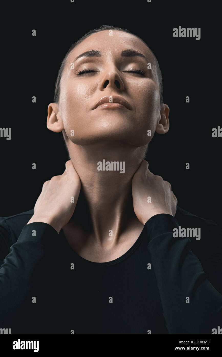 tired young fitness woman stretching neck isolated on black Stock Photo ...