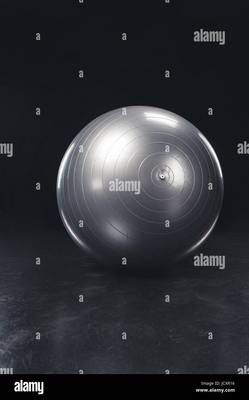 Shiny gray fitness ball on black background Stock Photo - Alamy