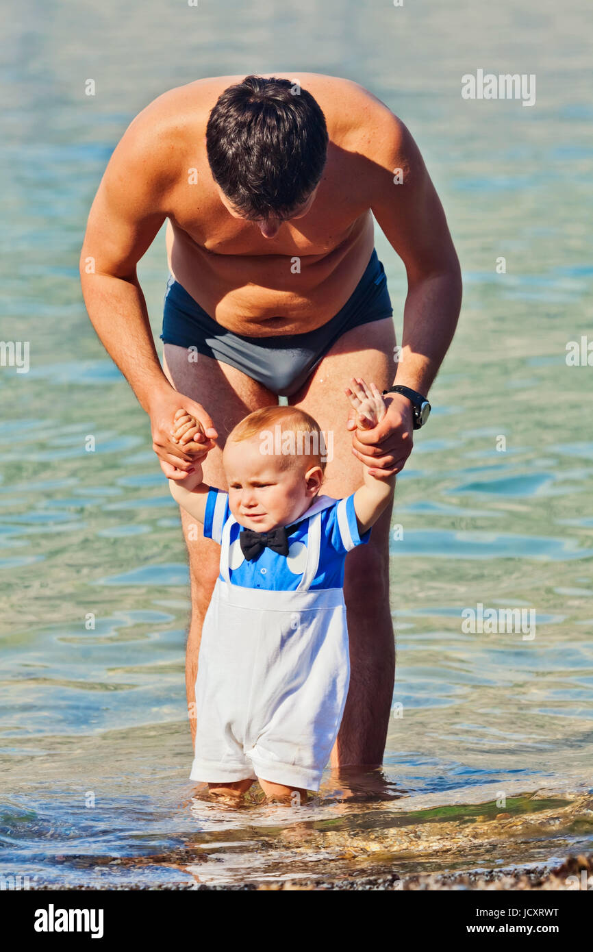 Father bathing his little son in the sea Stock Photo - Alamy