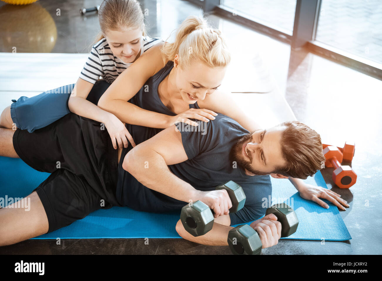 Happy family having fun at gym, man holding dumbbells Stock Photo - Alamy