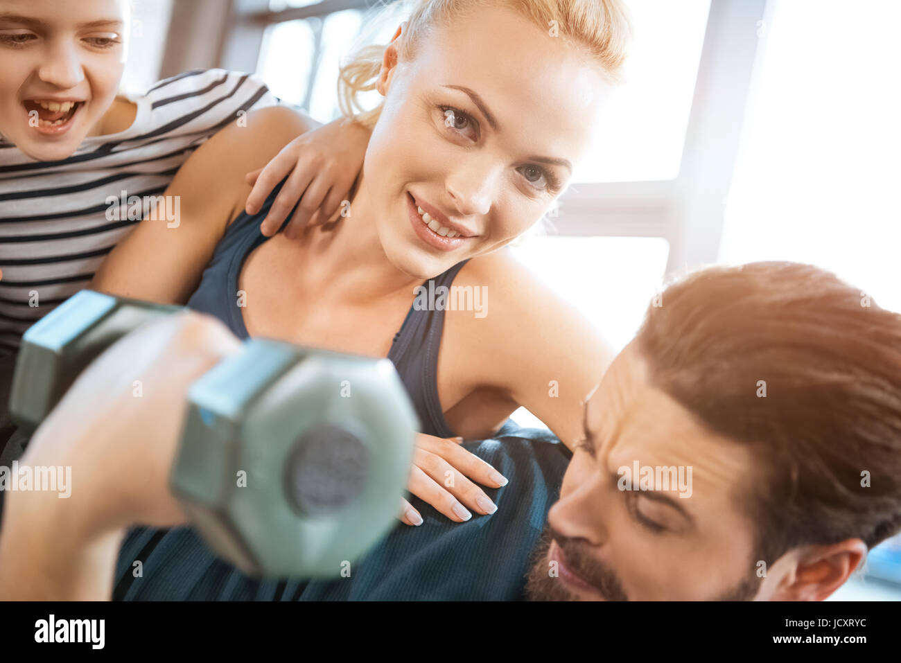 Happy family having fun at gym, man holding dumbbells Stock Photo - Alamy