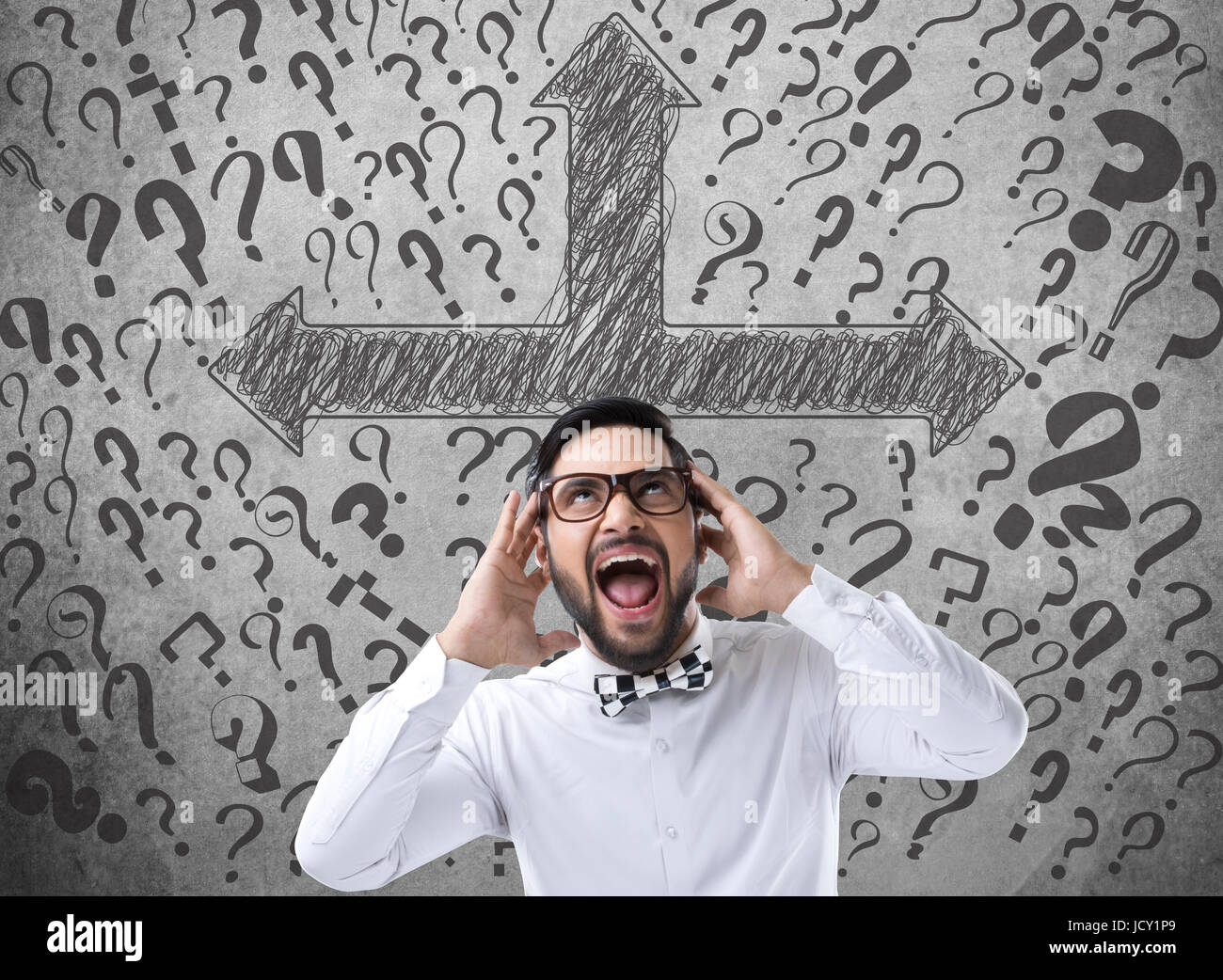 Shocked businessman with arrow symbols and question marks on wall Stock ...