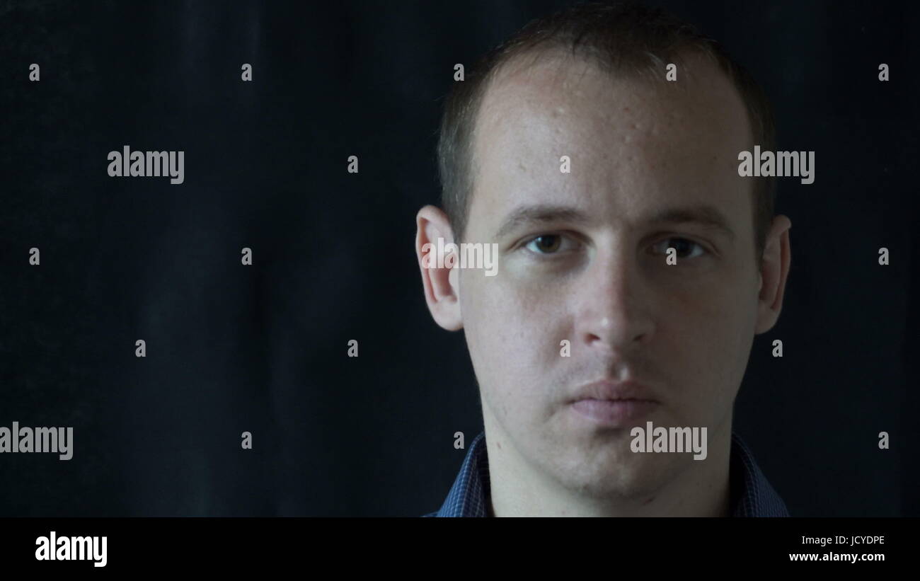 portrait of a young man staring at camera,black background Stock Photo ...
