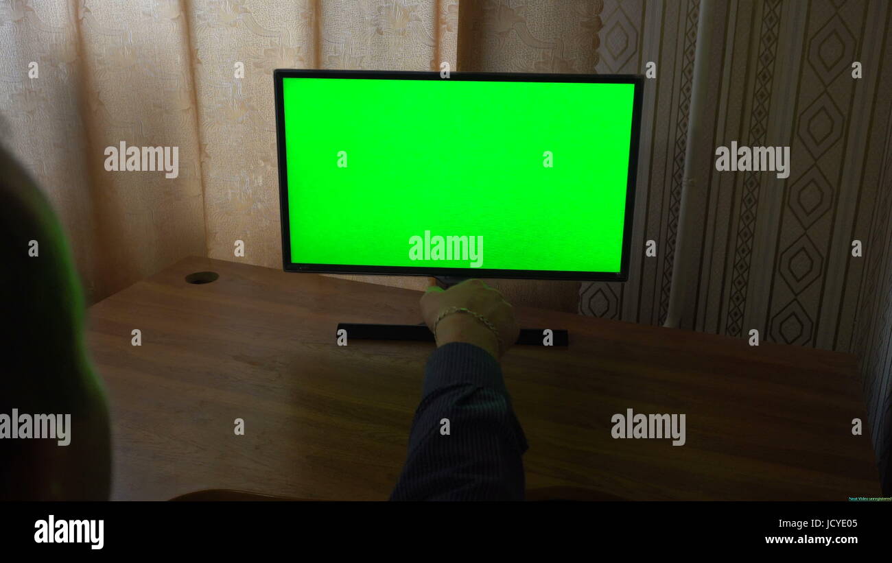 Male Hand With TV Remote Switching Channels On A Green Screen TV Point ...