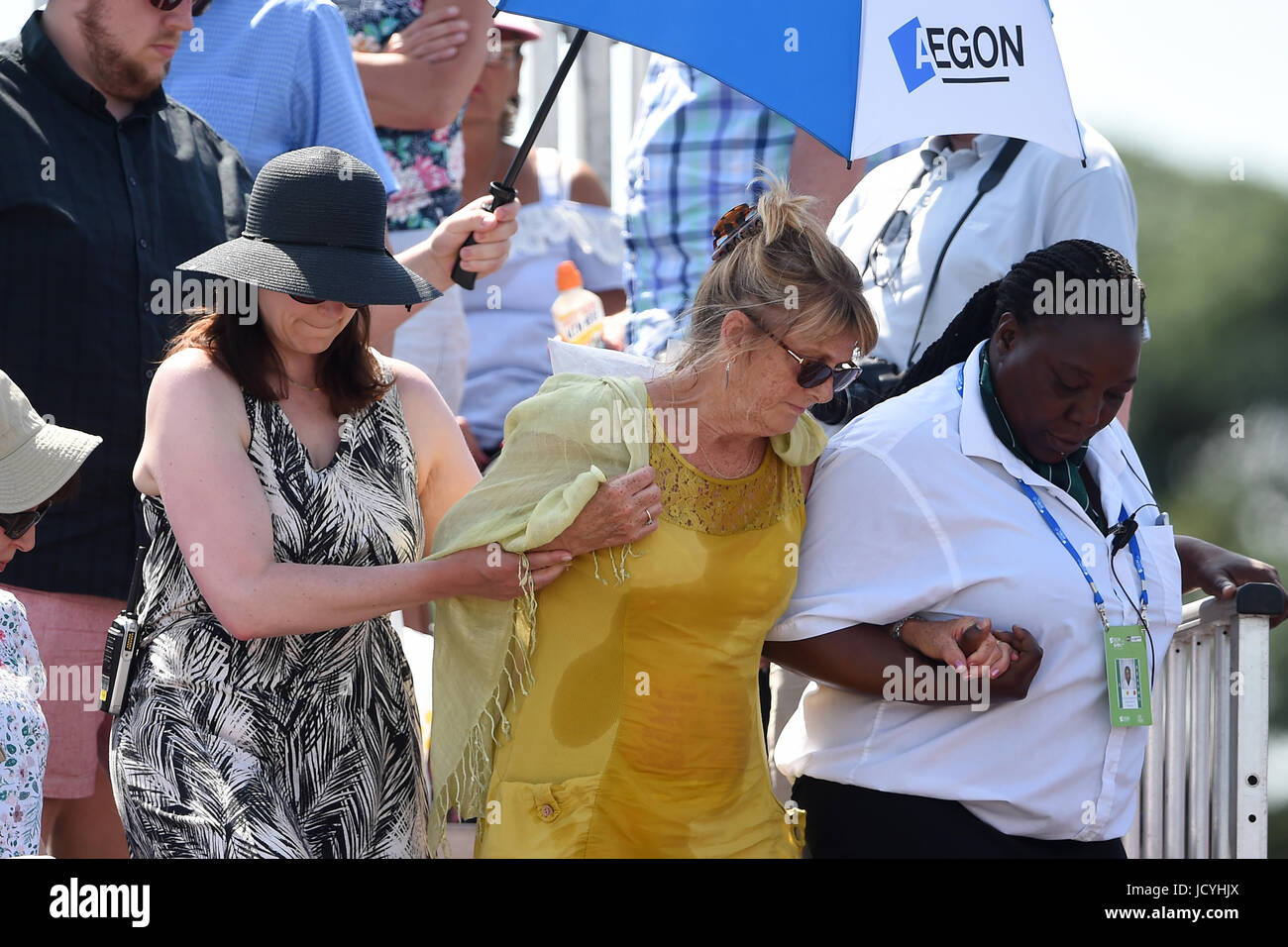 A spectator is assisted after suffering from the heat during day six of ...
