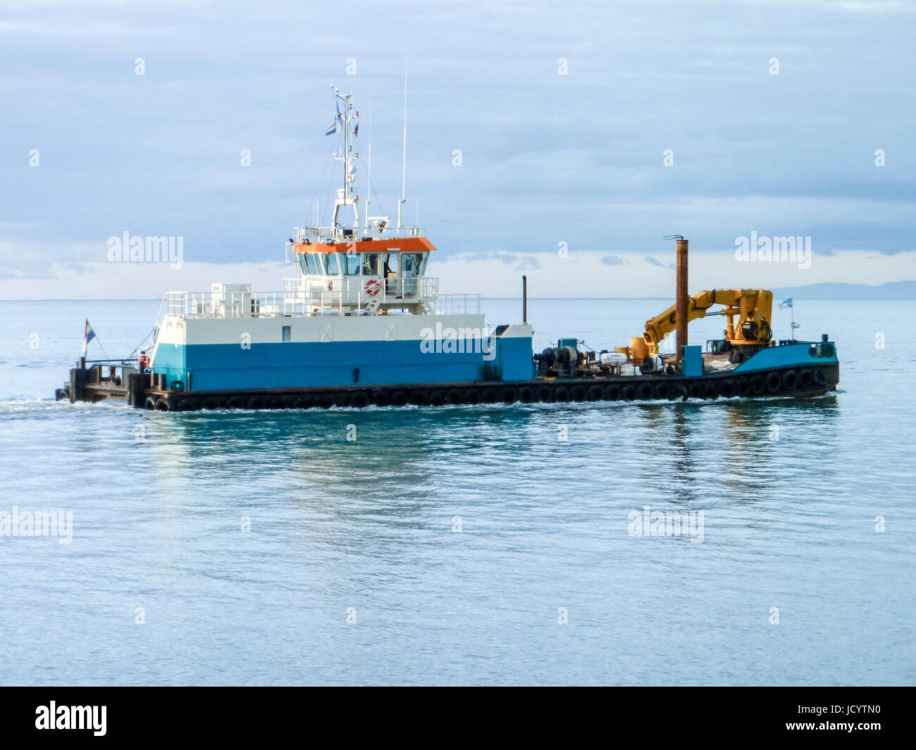 A small service ship in a cargo industrial port. A ship in the sea ...