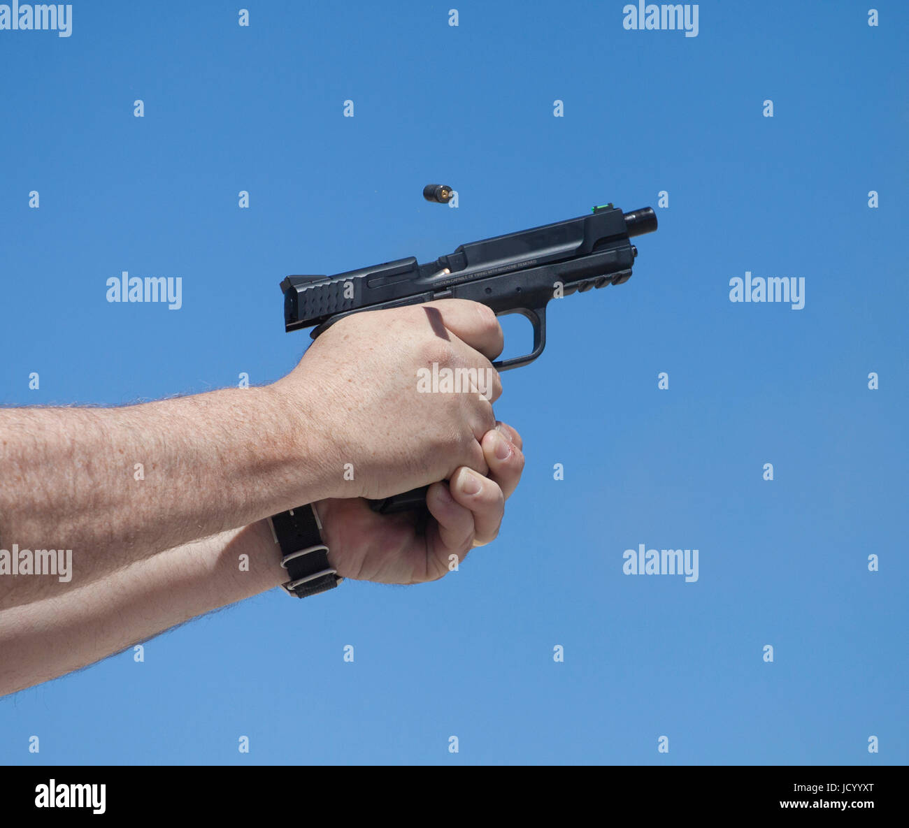 Empty brass leaving a semi auto handgun with sky behind Stock Photo - Alamy