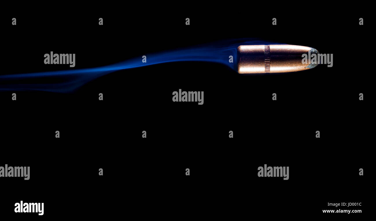 Blue smoke in a line behind a bullet on black Stock Photo - Alamy