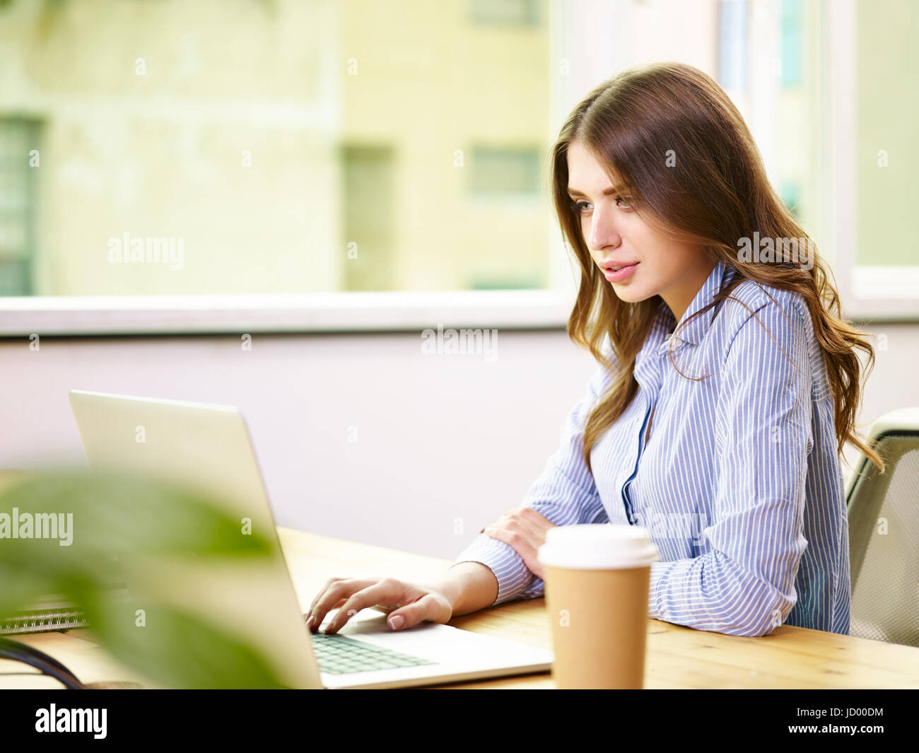 young caucasian businesswoman working in office using laptop computer ...