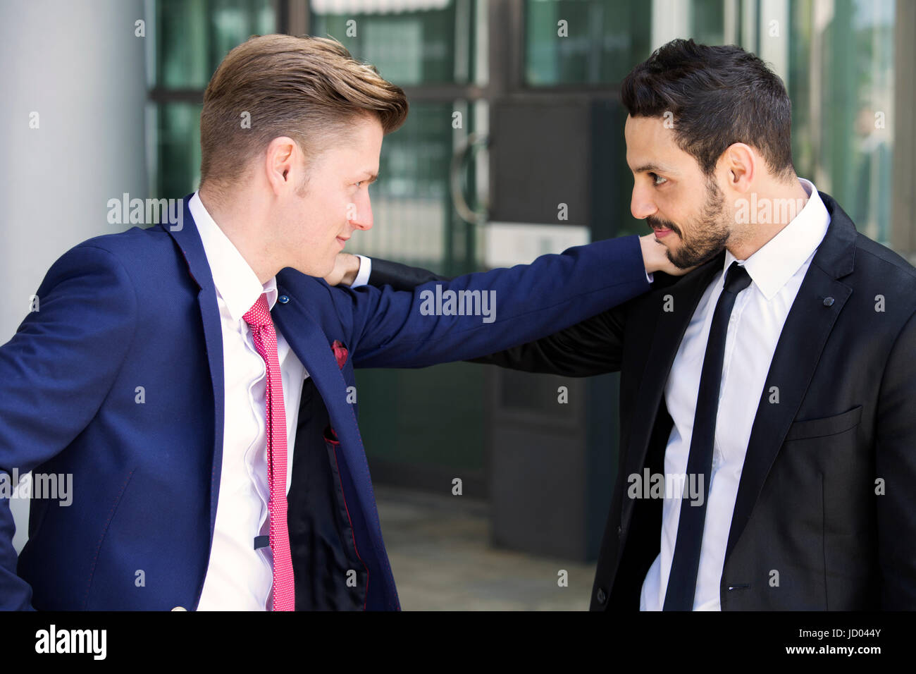 two handsome businessmen greeting each other outside Stock Photo - Alamy