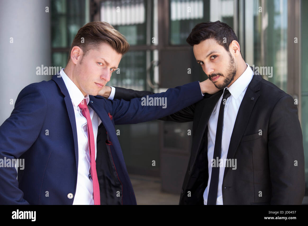 two handsome businessmen looking serious into camera Stock Photo - Alamy