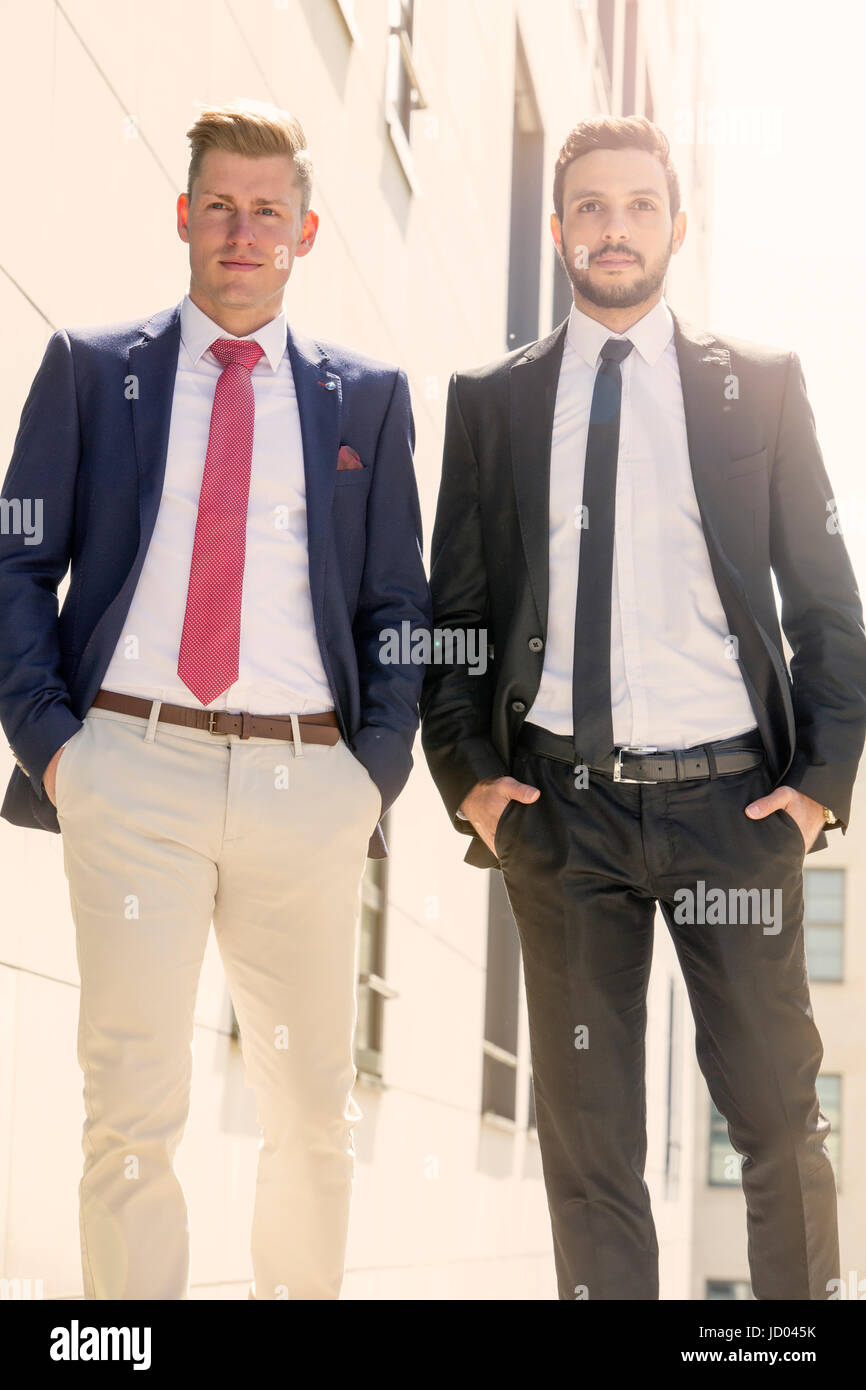 two handsome businessmen standing outside on a sunny day Stock Photo ...