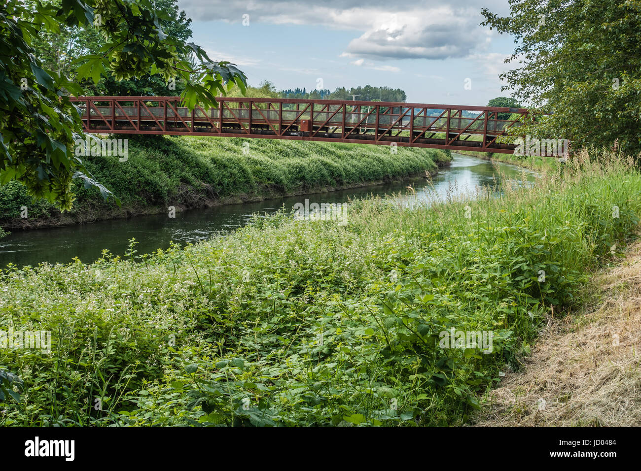 A rusted metal bridge spans the Green River in Kent, Washington Stock ...