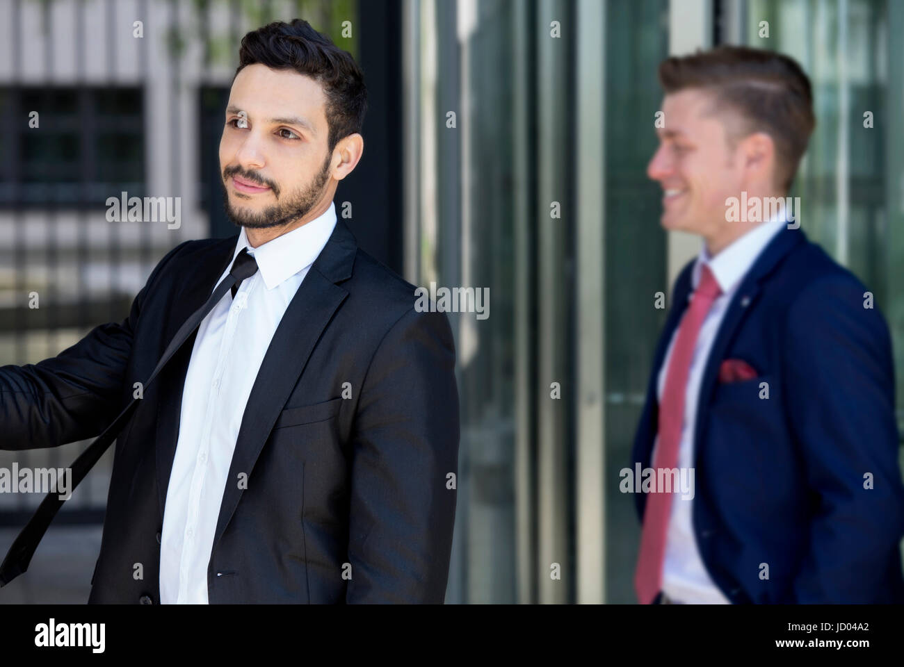 two handsome businessmen standing outside and smiling Stock Photo - Alamy