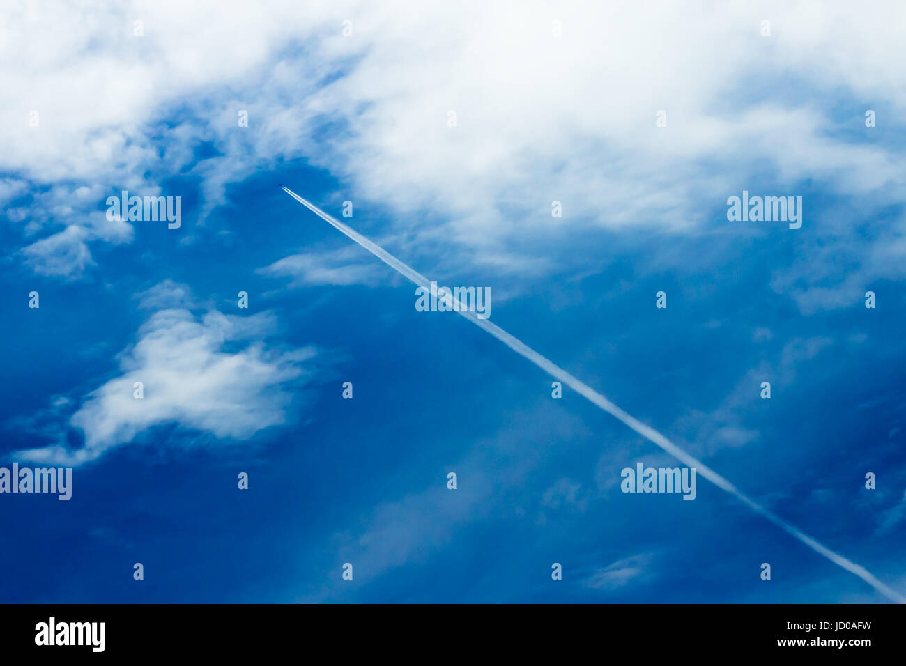 Long contrail from aviation engine in the blue sky. Contrail is a ...