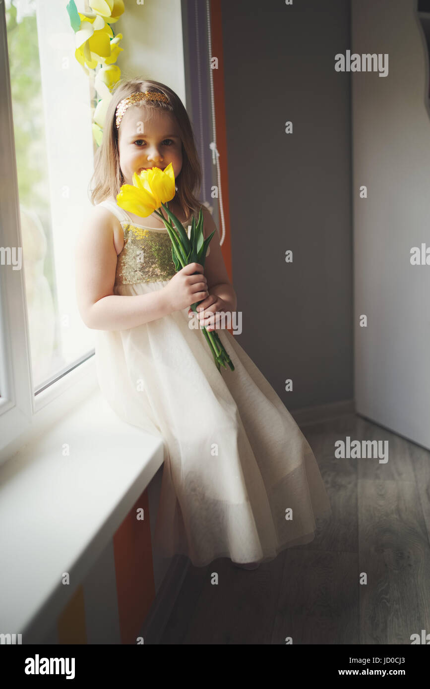 funny girl with yellow tulips at home Stock Photo - Alamy