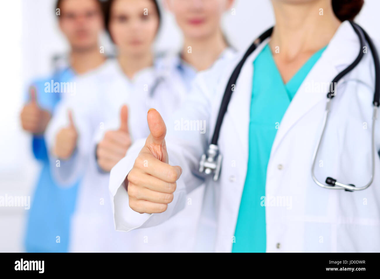 Group of doctors showing OK or approval sign with thumb up. High level ...