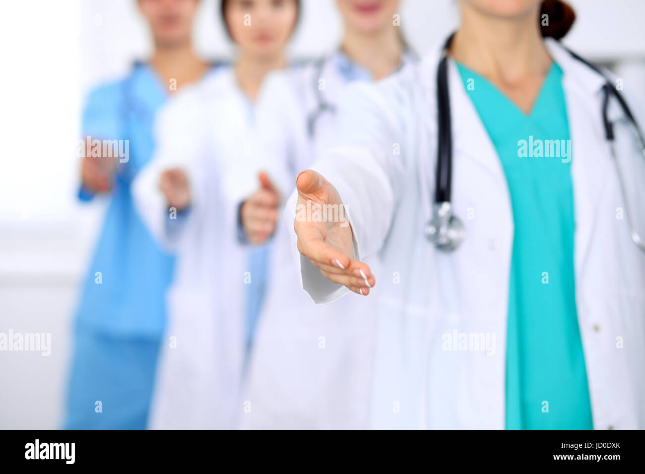 Group of doctors offering helping hand in hospital closeup. Friendly ...