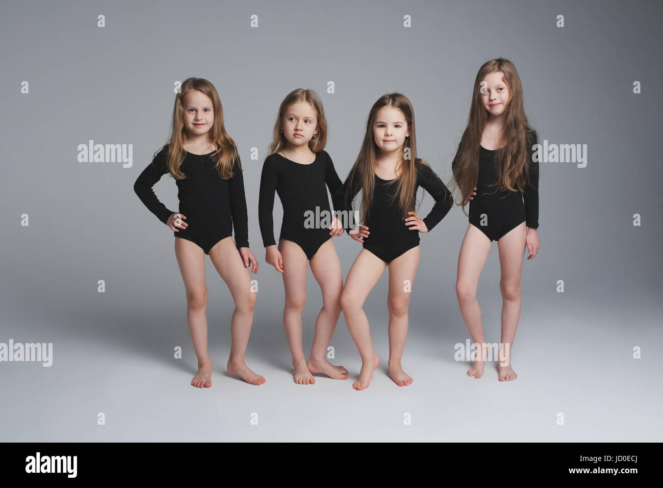 four young beautiful models on grey Stock Photo - Alamy