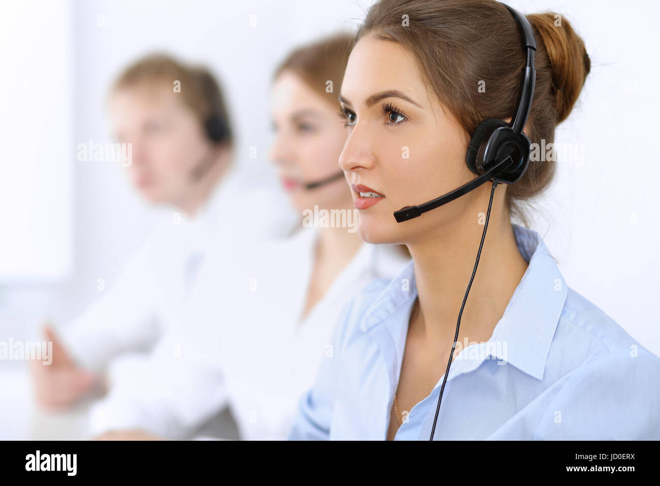 Call center. Focus on beautiful woman in headset Stock Photo - Alamy